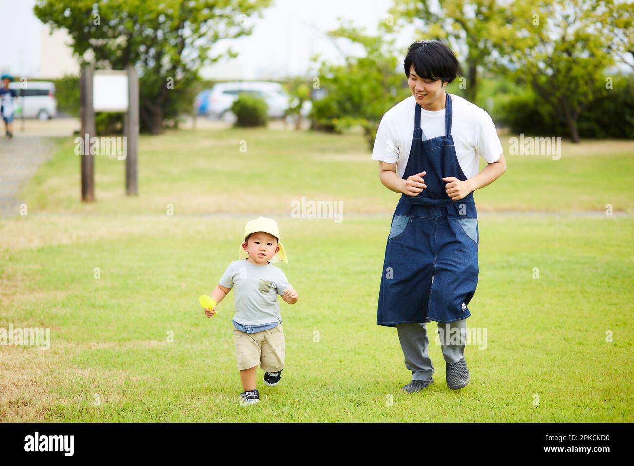 Child and nursery teacher running on the grass Stock Photo - Alamy