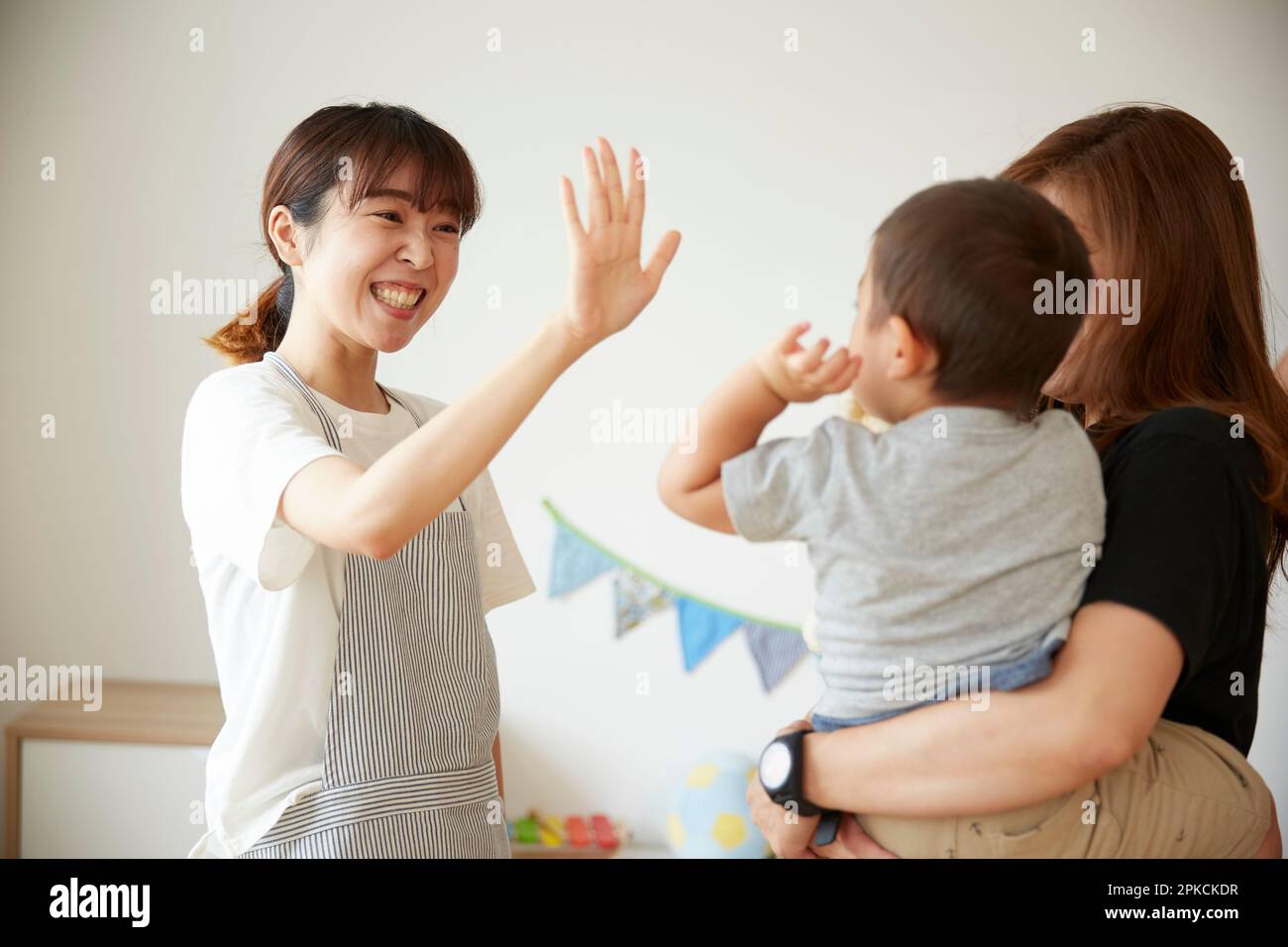 Child care worker waving to a child coming home Stock Photo - Alamy