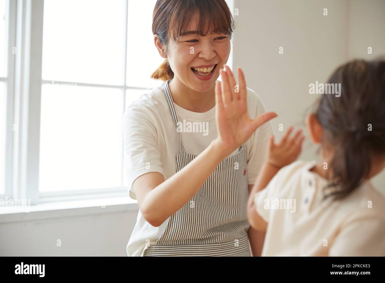Child care worker waving to a child coming home Stock Photo - Alamy