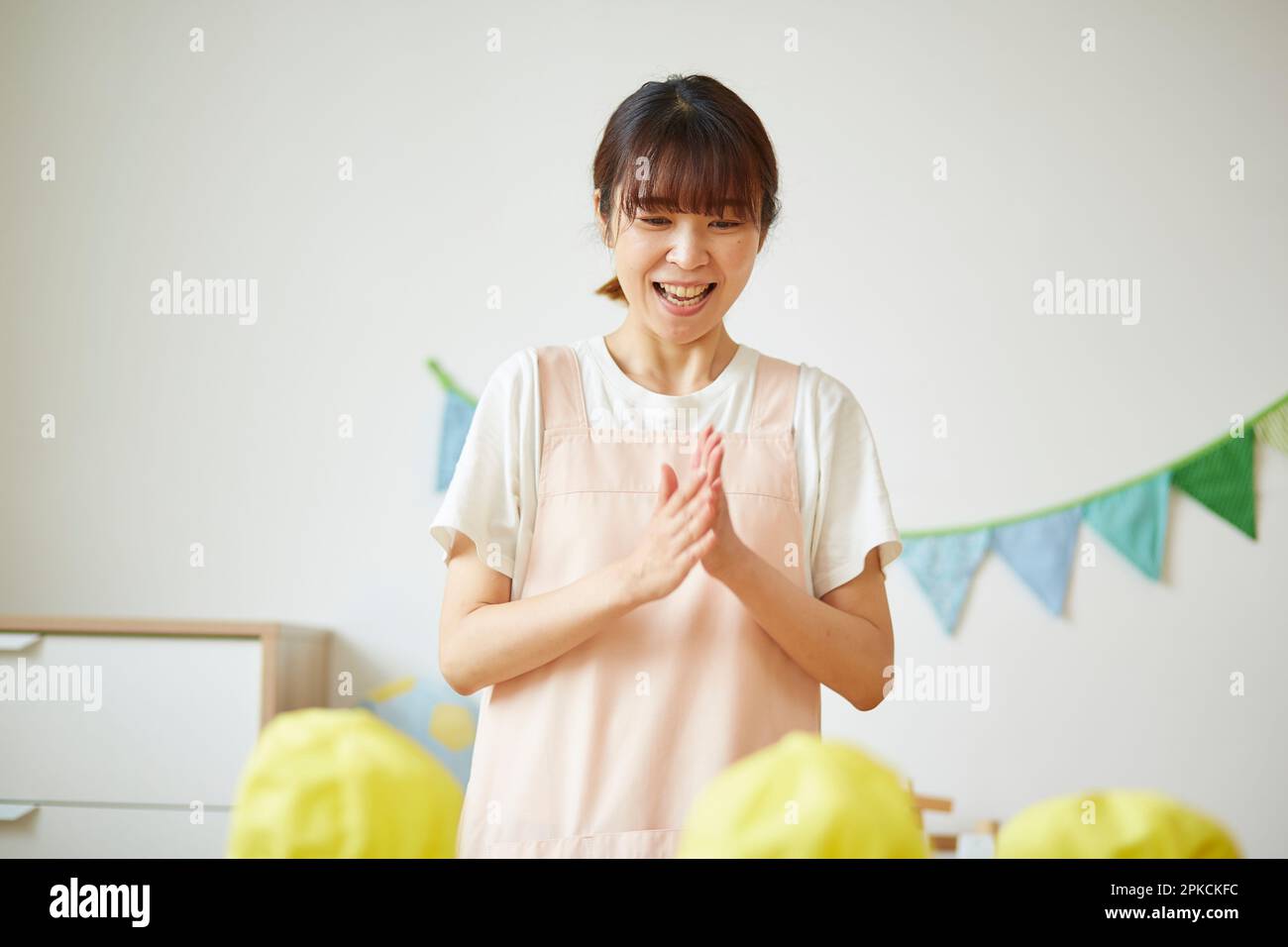 Child care worker clapping her hands in front of children Stock Photo ...