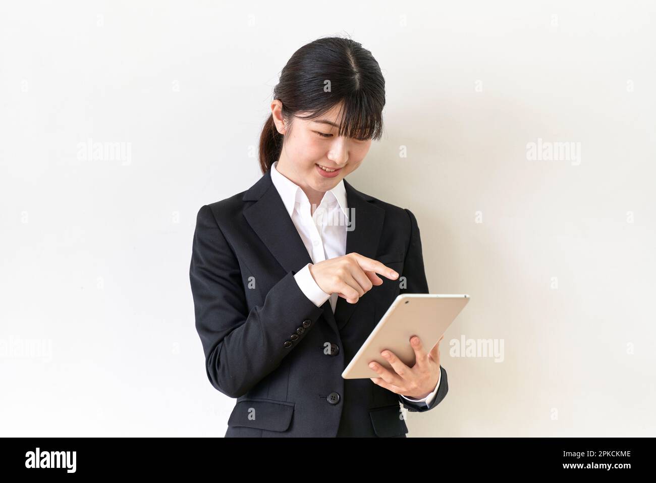 Female student in suit operating iPad Stock Photo - Alamy