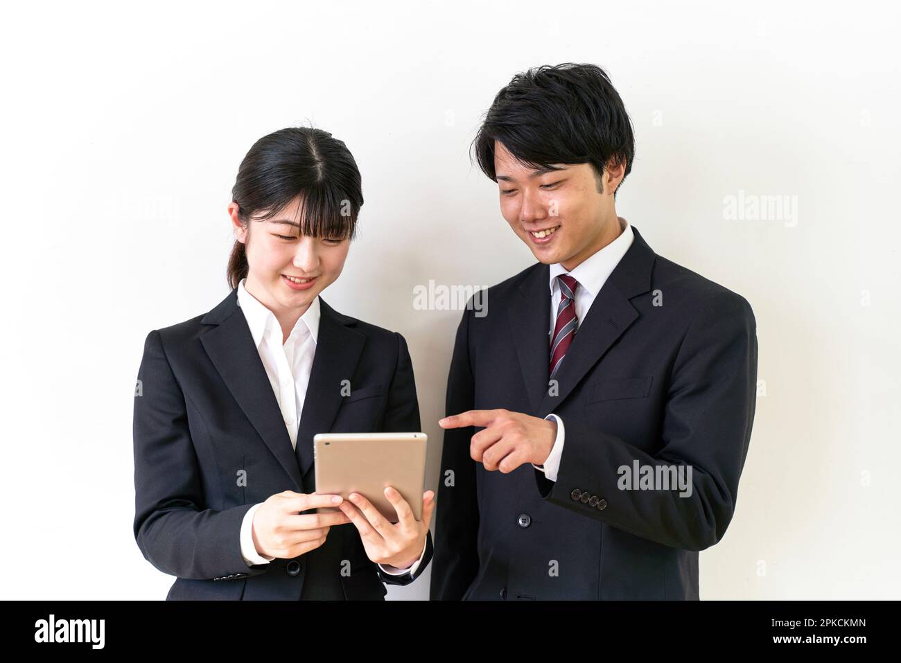Male and female students in suits operating an iPad Stock Photo - Alamy