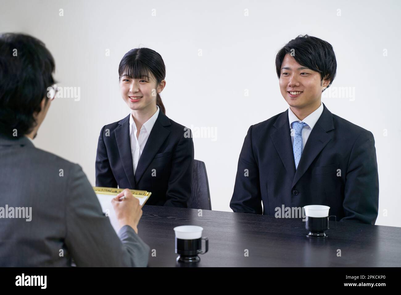 Male and female jobseekers talking with an interviewer during a group ...