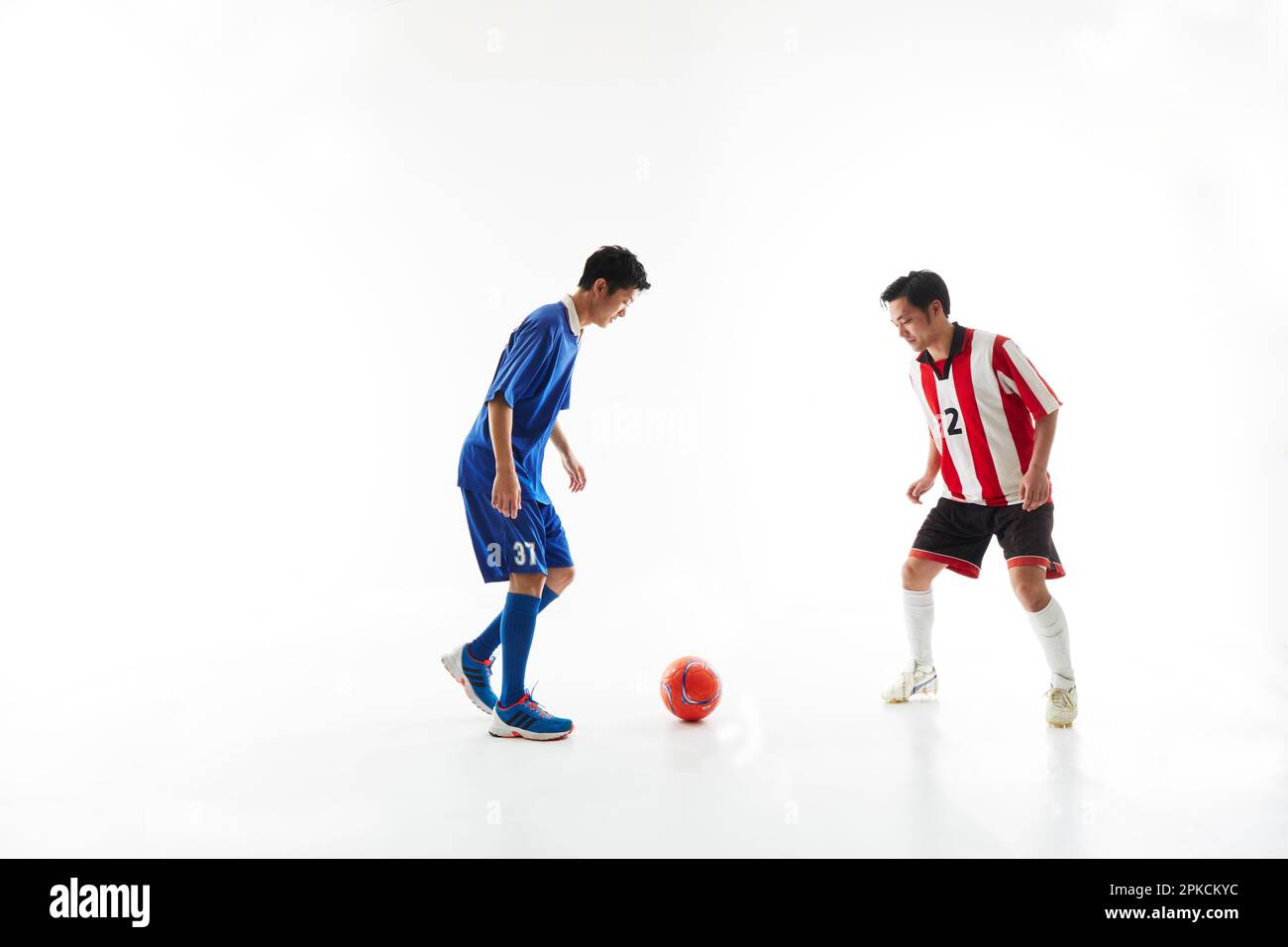 People kicking and defending a ball at a soccer match Stock Photo - Alamy