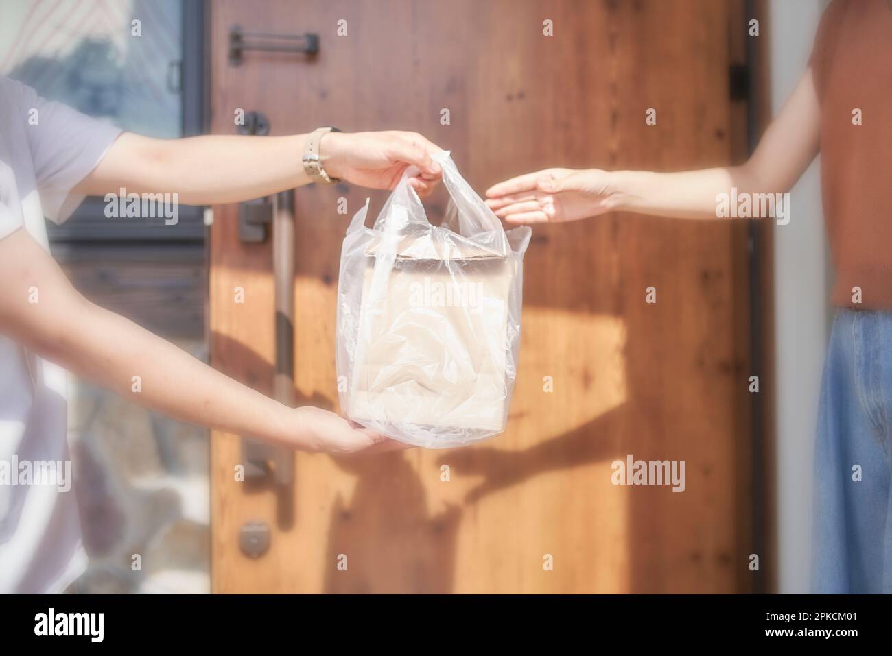 Woman receiving food from food delivery delivery man Stock Photo - Alamy