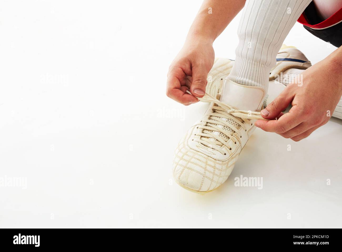 Soccer player tying spike laces Stock Photo - Alamy