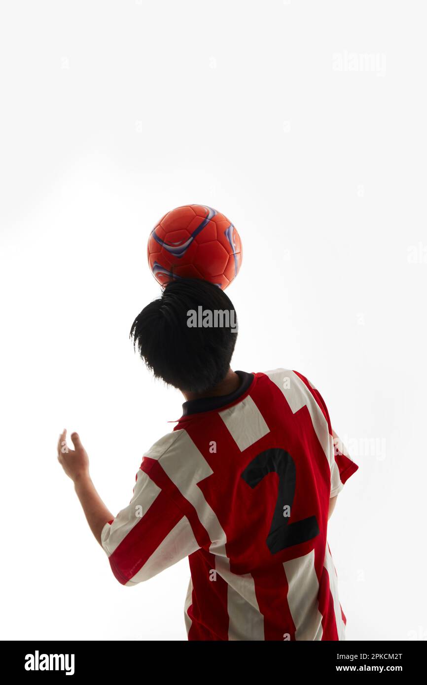 Soccer player balancing ball on forehead Stock Photo - Alamy