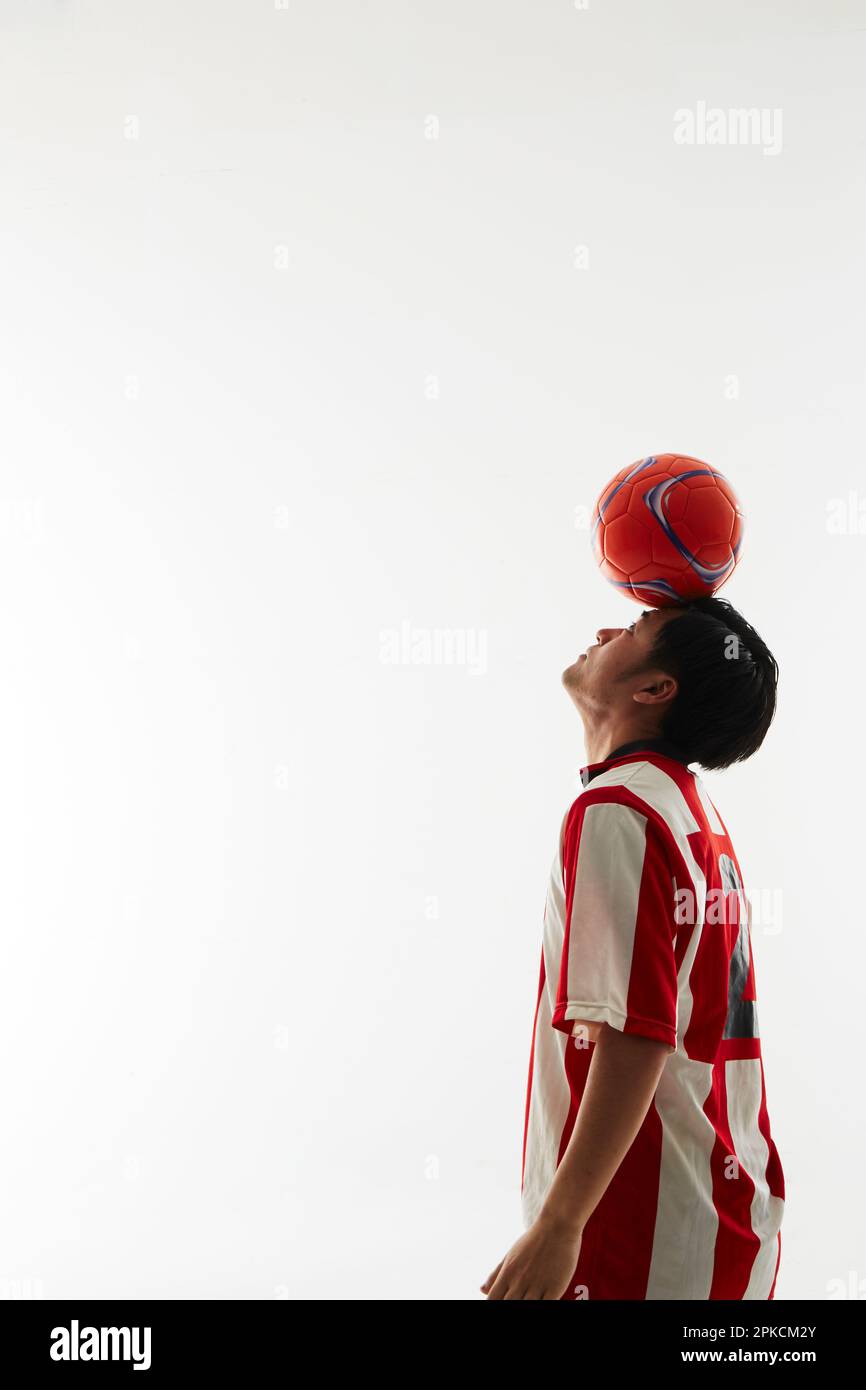 Soccer player balancing ball on forehead Stock Photo - Alamy