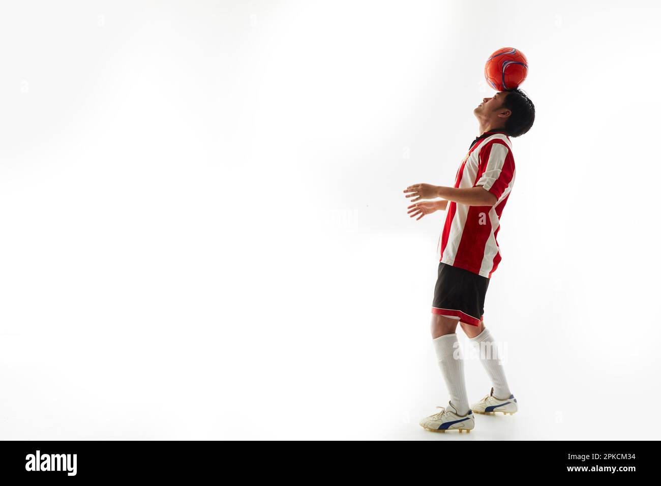Soccer player balancing ball on forehead Stock Photo - Alamy