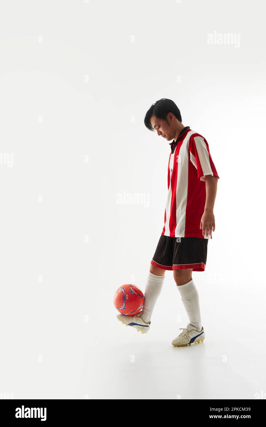 Soccer player balancing ball on back of foot Stock Photo - Alamy