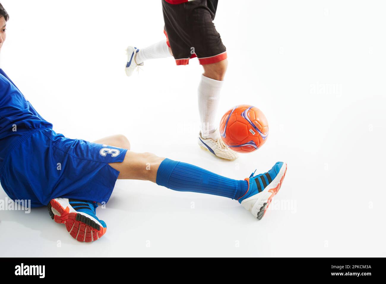 Soccer player sliding to cut off opponent's ball Stock Photo - Alamy