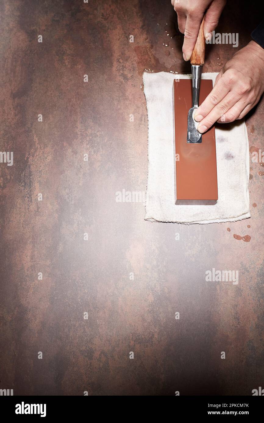 Man's hand sharpening chisel Stock Photo - Alamy