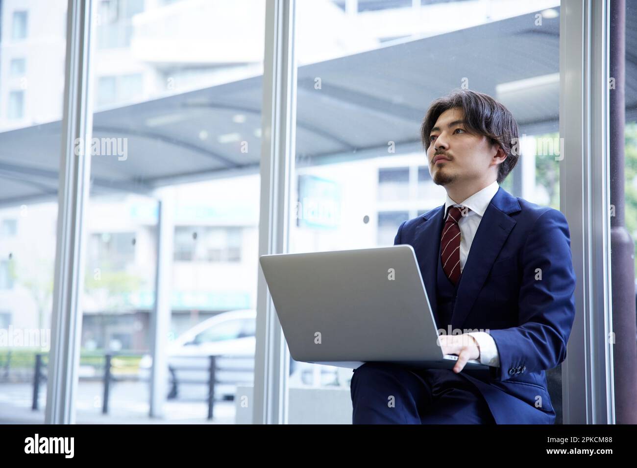 Man in suit sitting operating laptop computer Stock Photo - Alamy