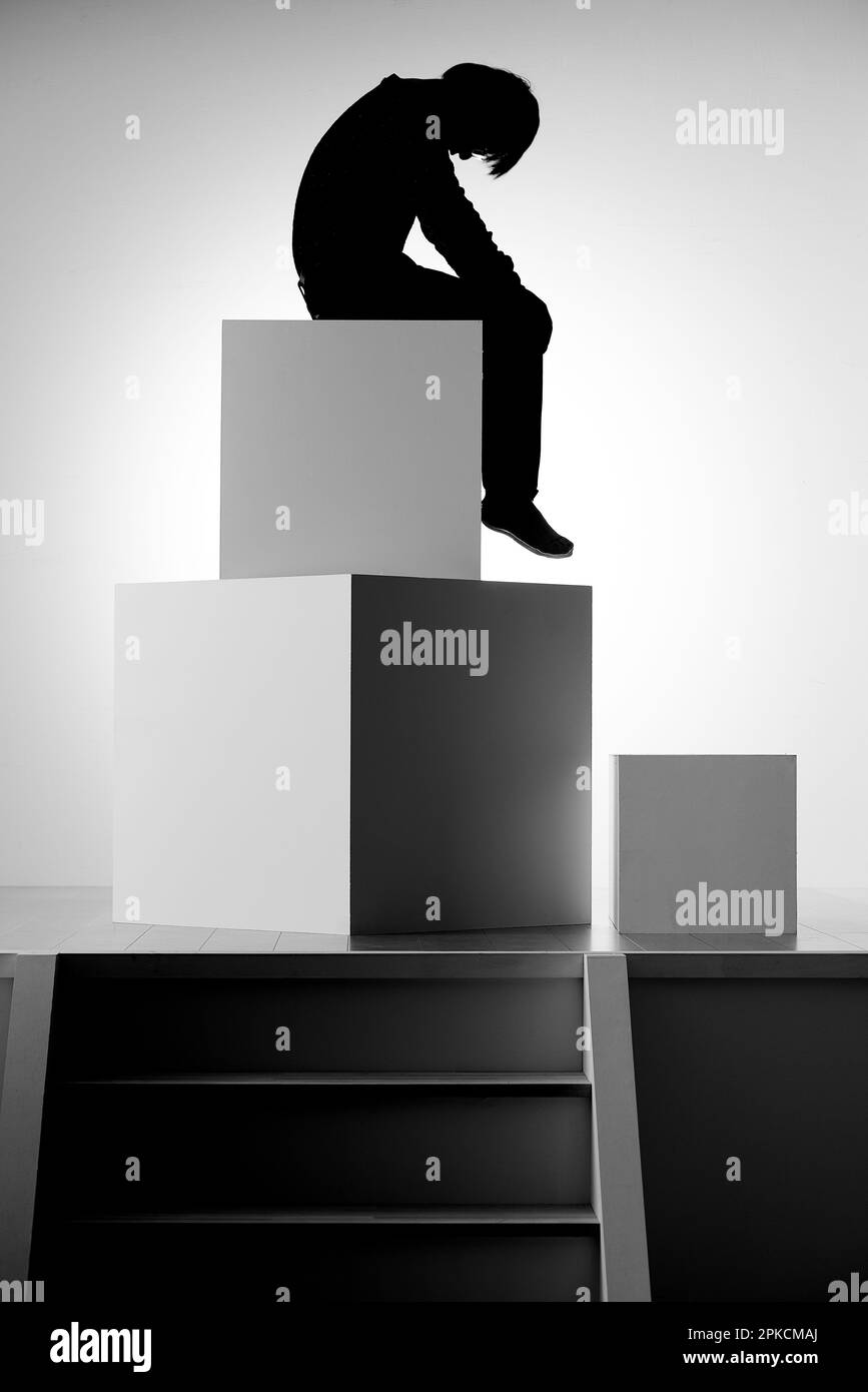 Depressed figure sitting on object made by combination of squares Stock ...