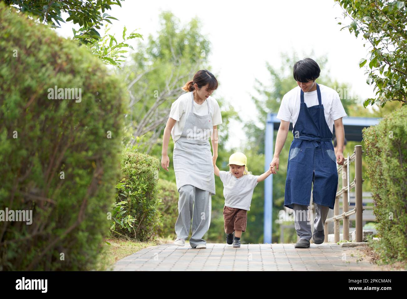 Male and female child care workers holding hands with a child Stock ...