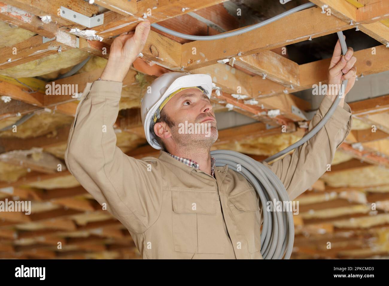 worker making mounting for an electric cable in ceiling Stock Photo - Alamy