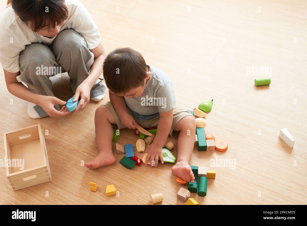 Female child care worker with children playing with toys Stock Photo ...