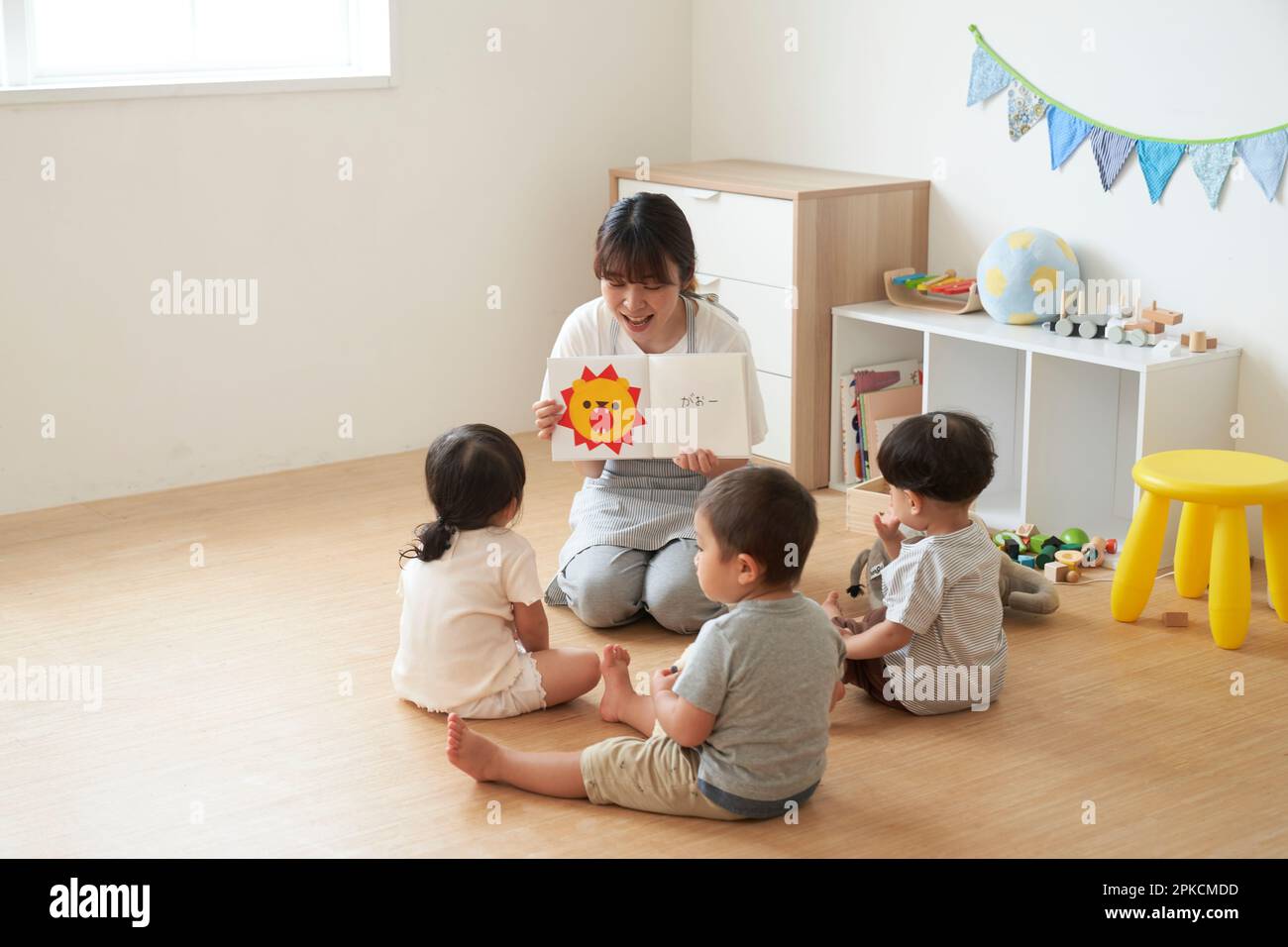 Female child care worker reading picture books to children Stock Photo ... Female child care worker reading picture books to children Stock Photo ...