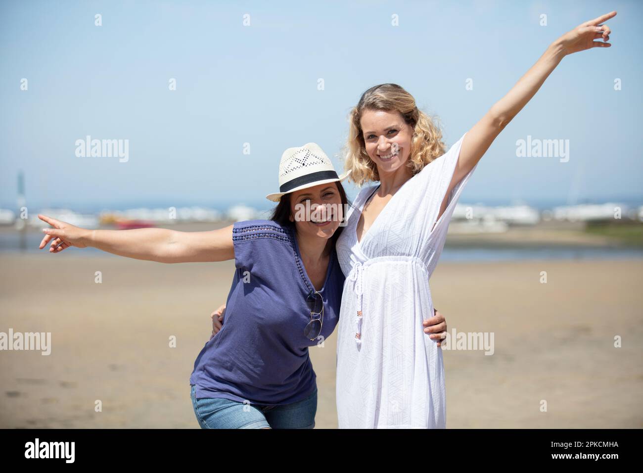 two happy female friends embracing each other on beach Stock Photo - Alamy