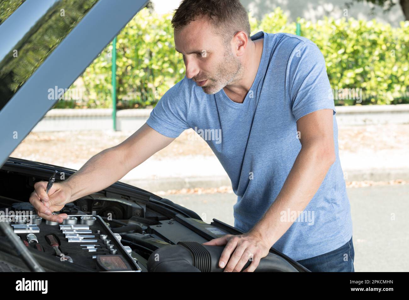 a man is fixing a car Stock Photo - Alamy