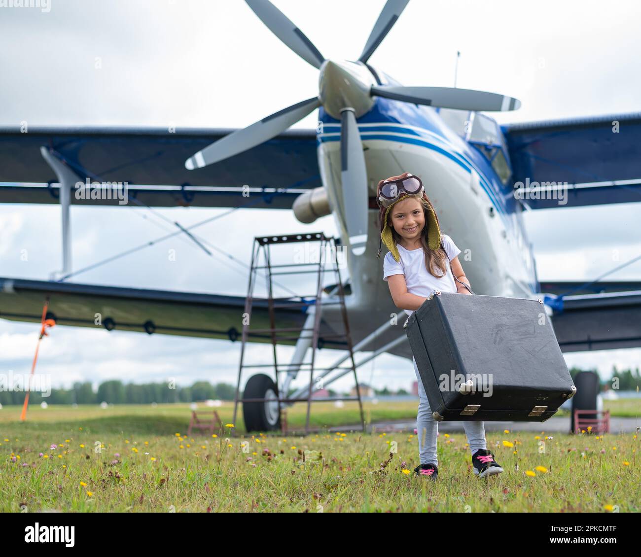 A cute little girl playing on the field by private jet dreaming of ...