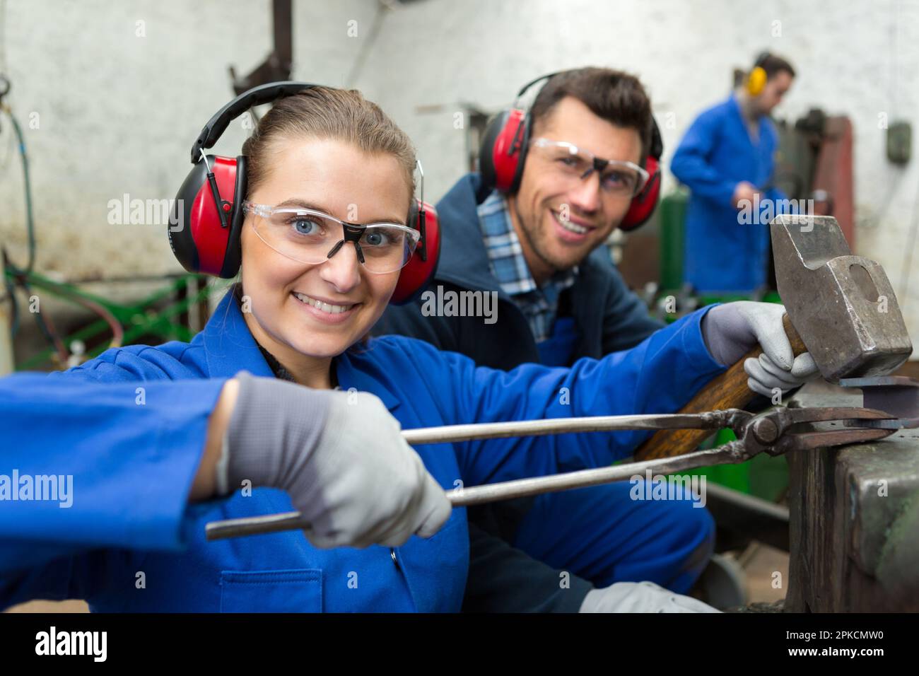 female and mame blacksmith working on metal Stock Photo - Alamy