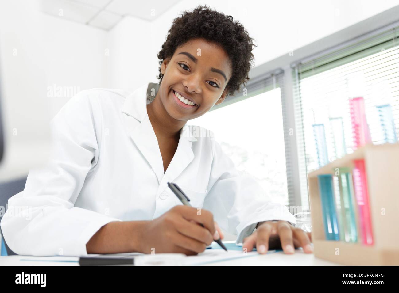 happy female worker taking notes in the lab Stock Photo - Alamy