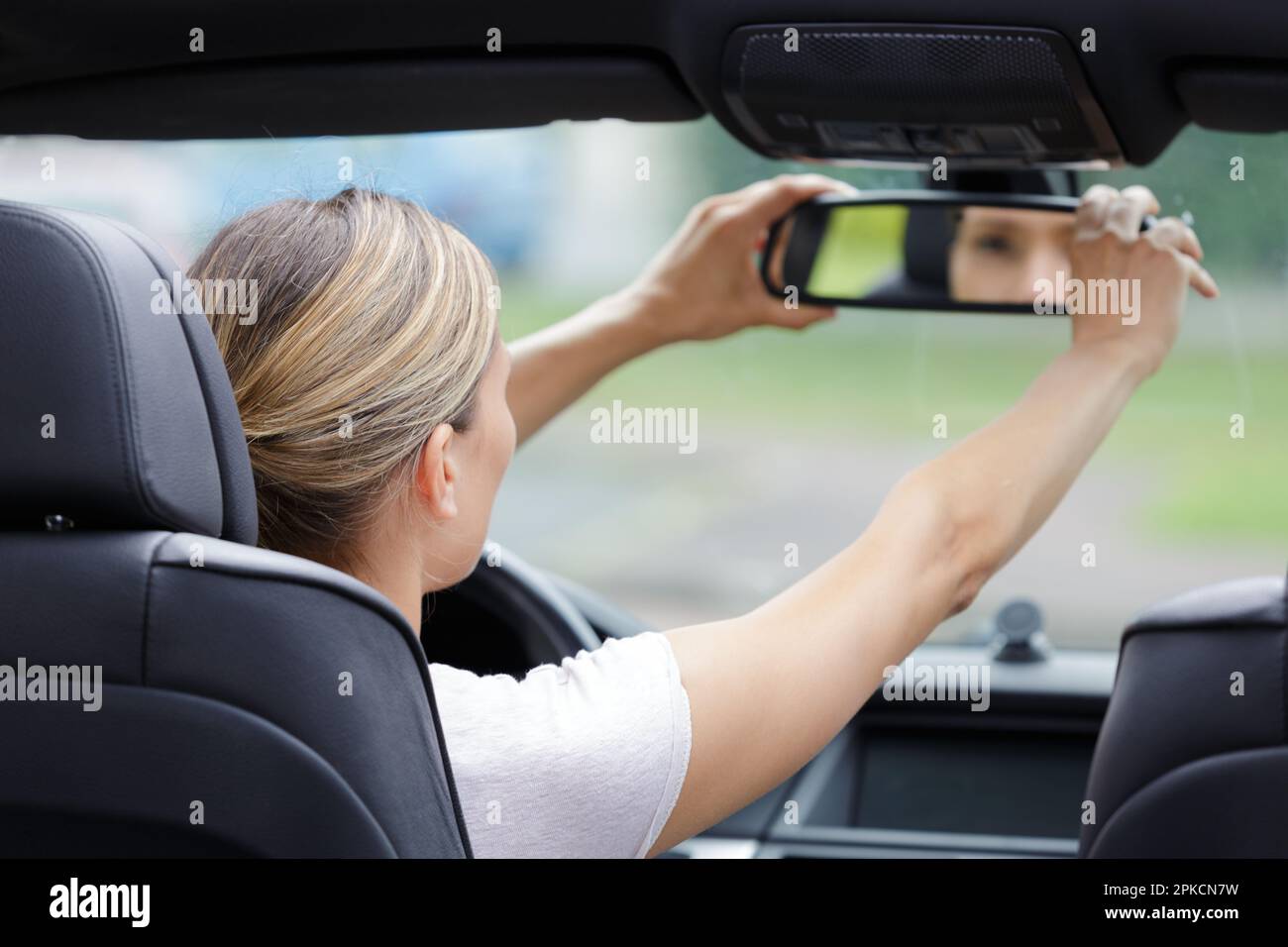 woman adjusting rearview mirror in the car Stock Photo - Alamy