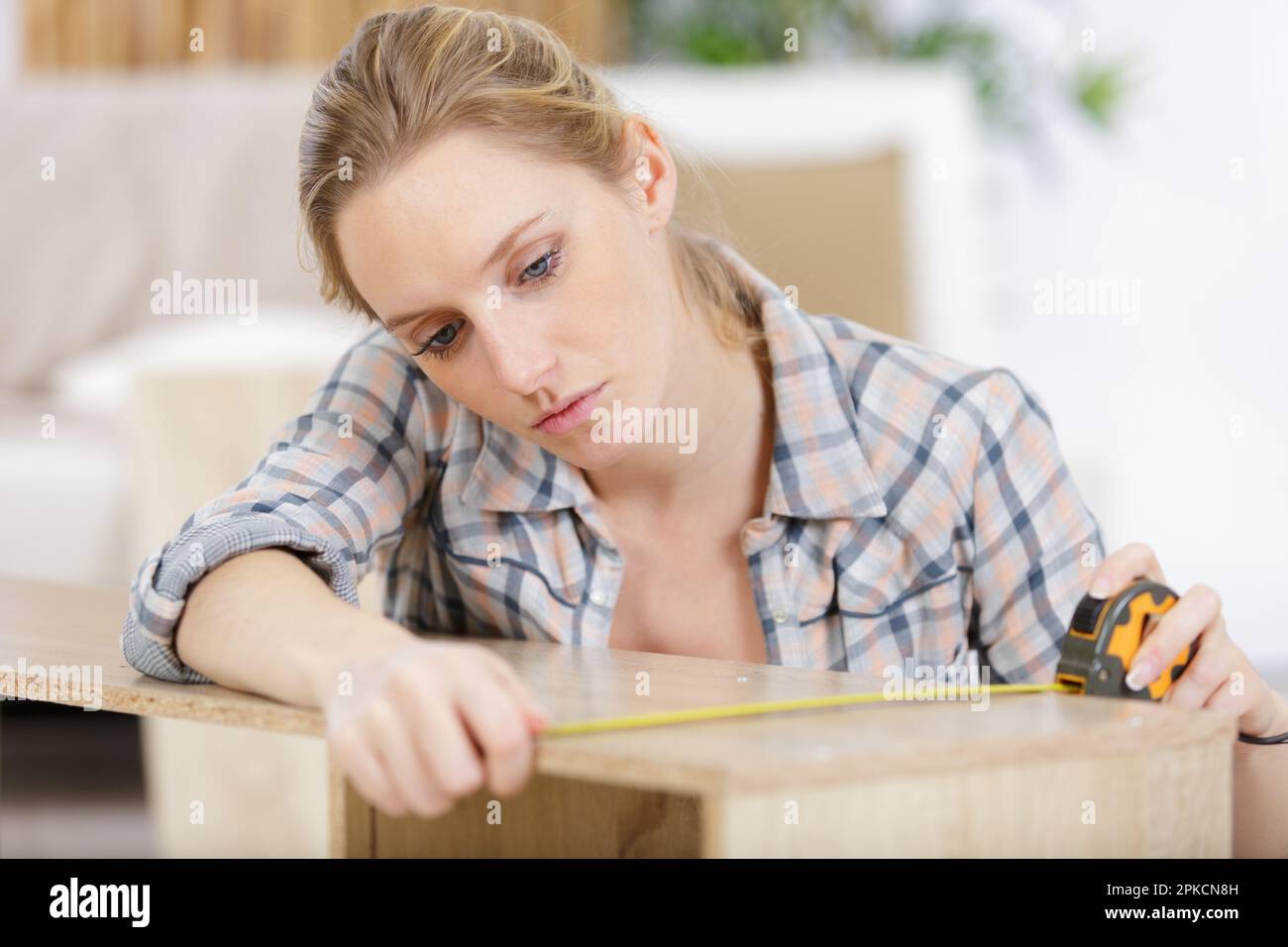 young woman checking the size of a shelf Stock Photo - Alamy