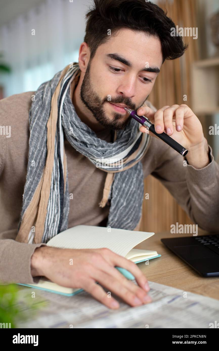 handsome guy reading the newspaper very interested at working desk ...