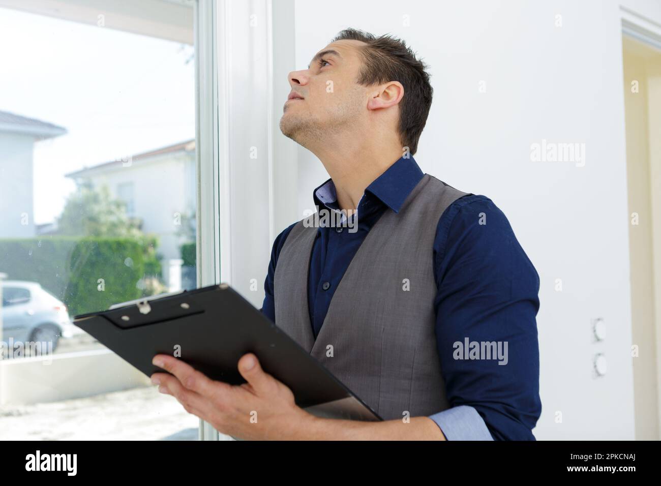 estate agent inspecting window in property Stock Photo - Alamy