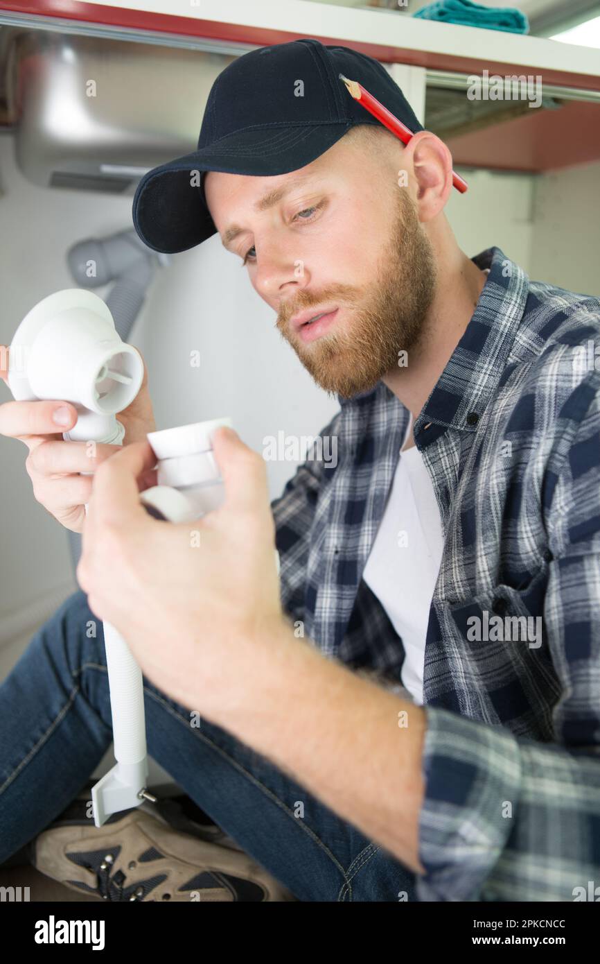 male plumber assembling waste pipes Stock Photo - Alamy