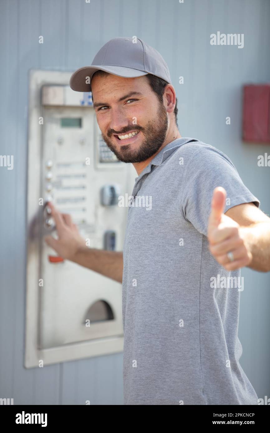 male maintenance worker by payment station holding thumbs-up Stock ...