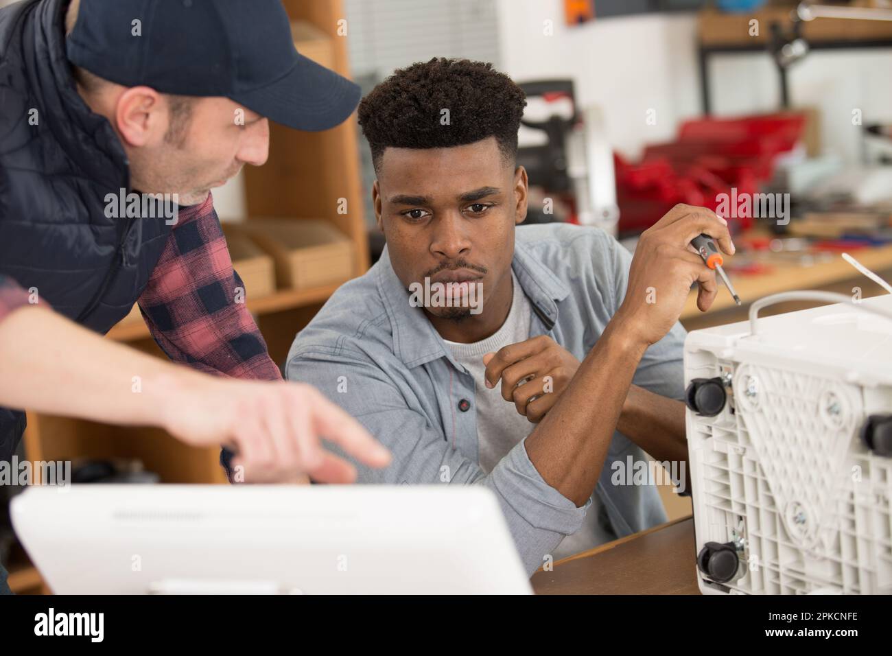 mentor explaining work to young focused intern Stock Photo - Alamy