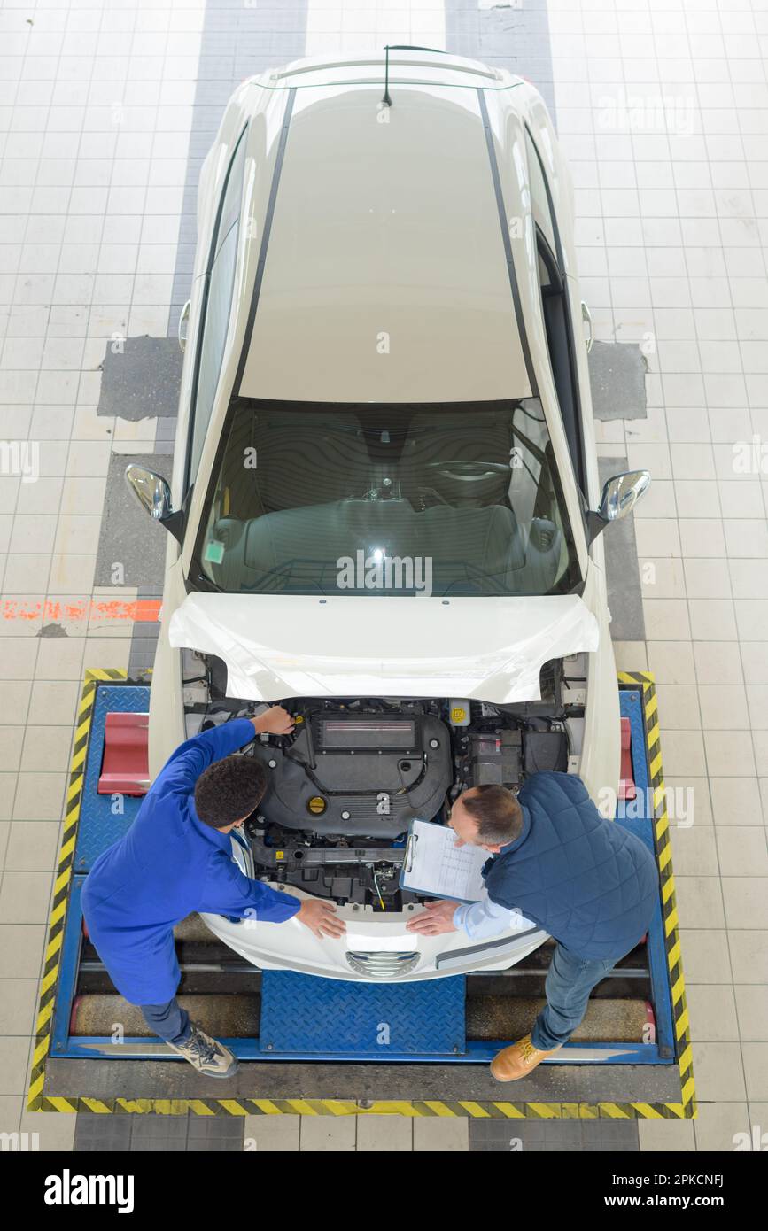 looking down on two mechanics working on car engine Stock Photo - Alamy