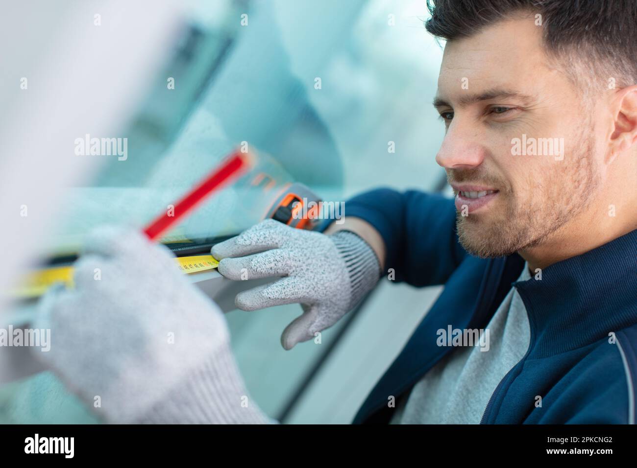 construction worker using measuring tape on a window Stock Photo - Alamy