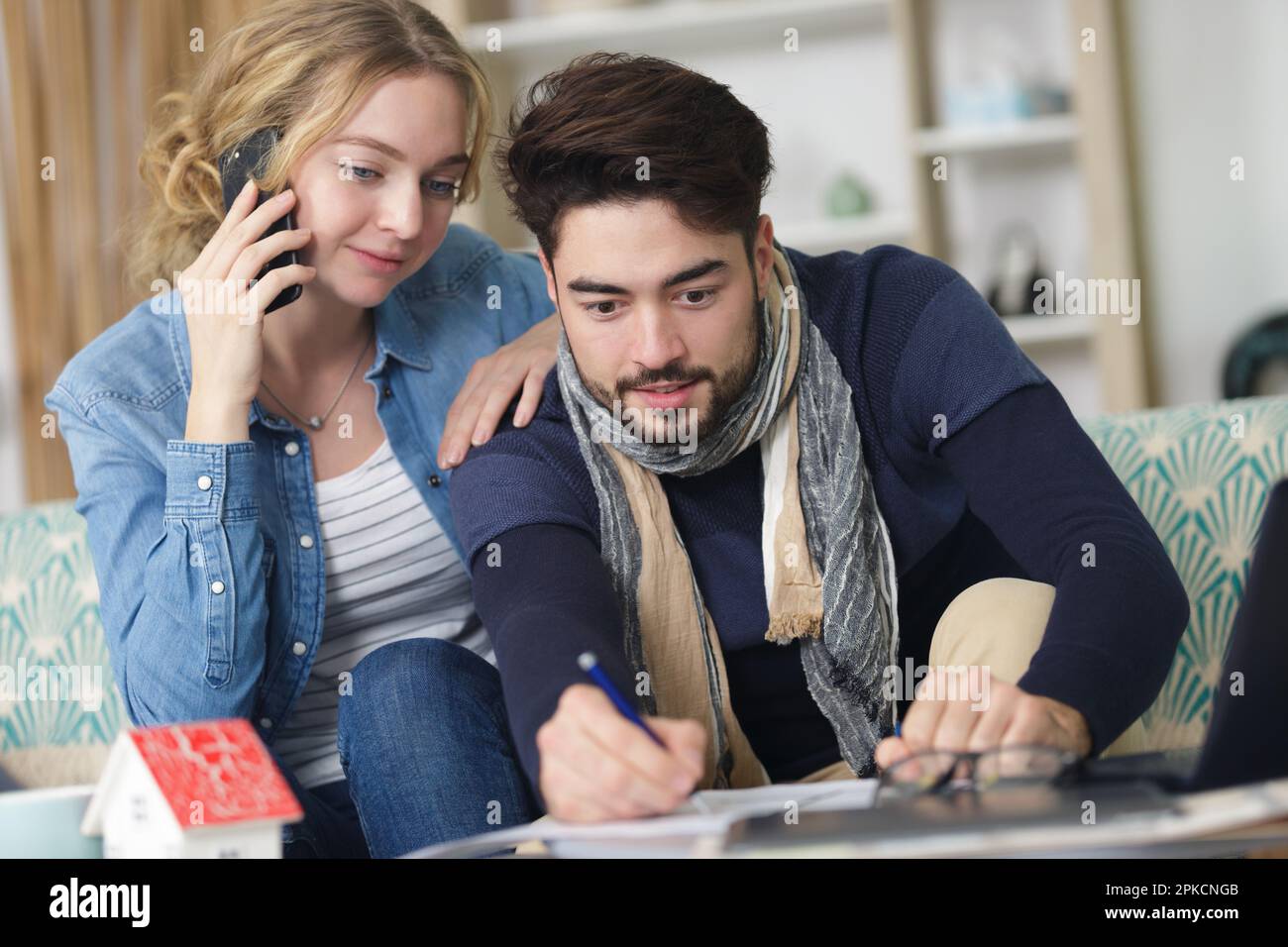 a smiling couple calculating bills Stock Photo - Alamy