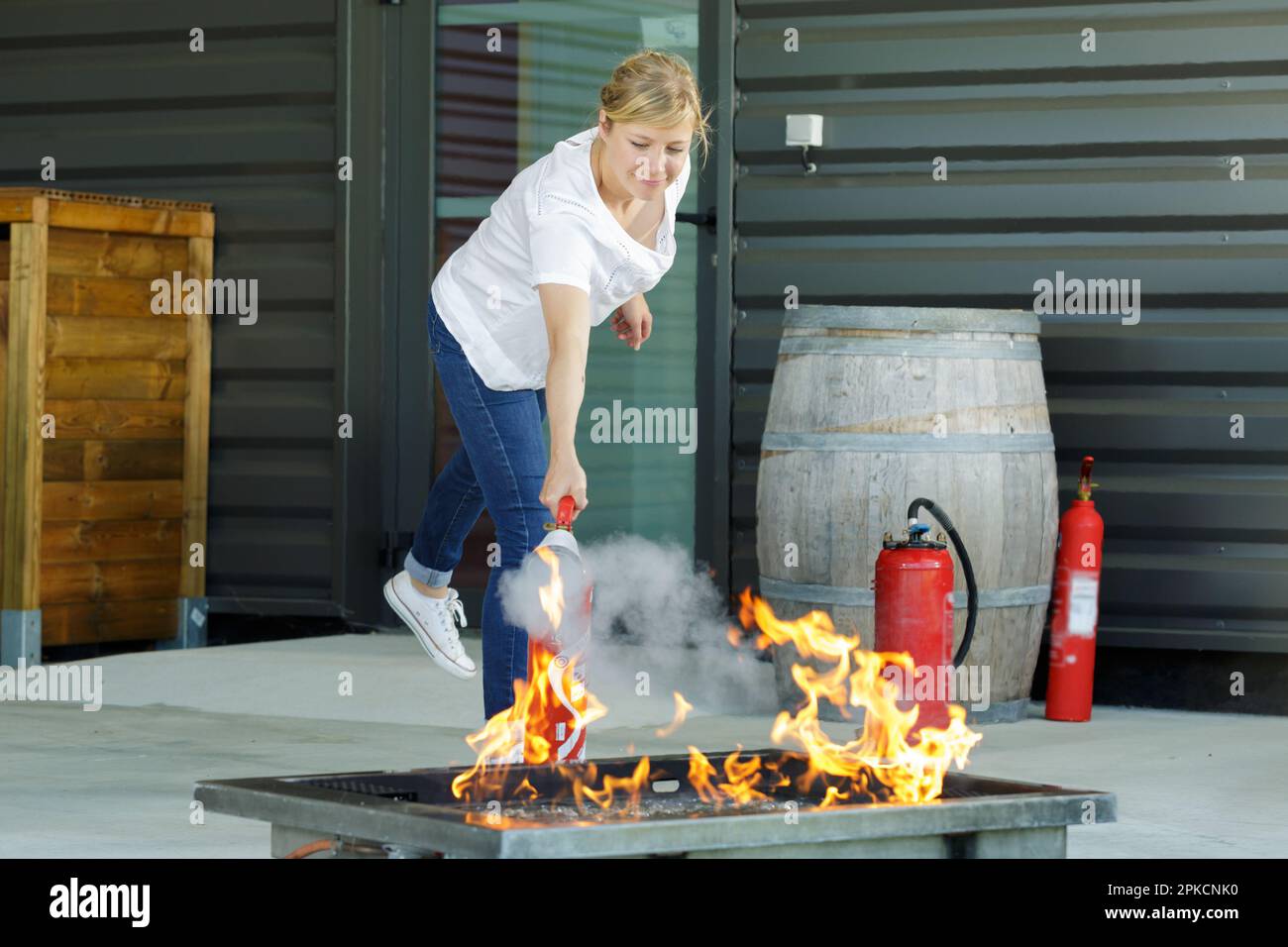 woman putting the fire out with an extinguisher Stock Photo - Alamy