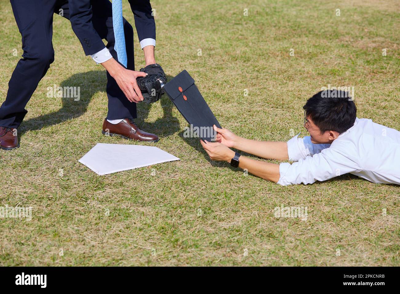 Man in suit with materials sliding into home base Stock Photo - Alamy