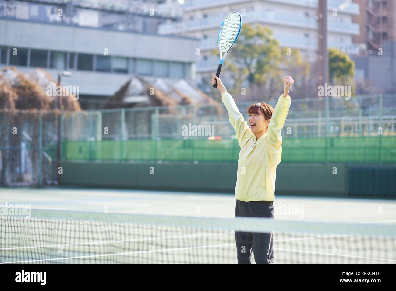 Happy woman on tennis court Stock Photo - Alamy