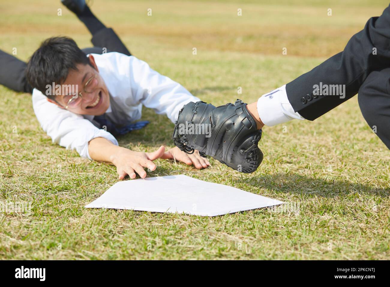 Man in suit sliding into home base Stock Photo - Alamy