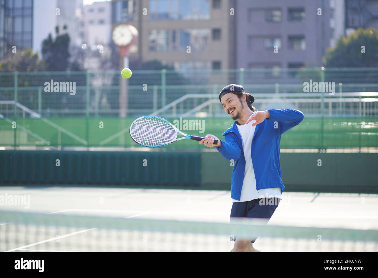 Man hitting a tennis ball back Stock Photo - Alamy