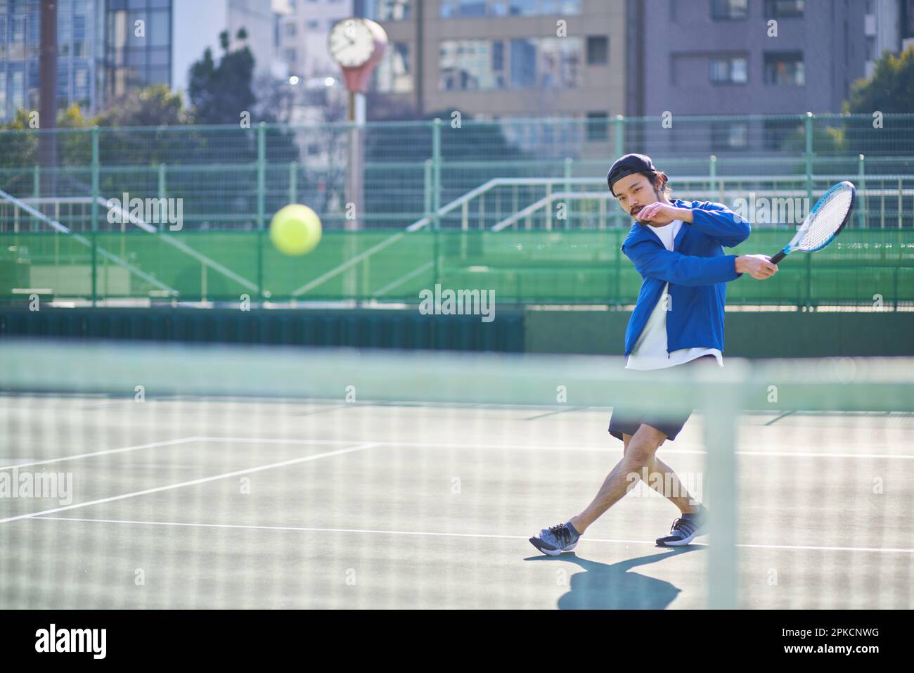 Man hitting tennis ball back Stock Photo - Alamy