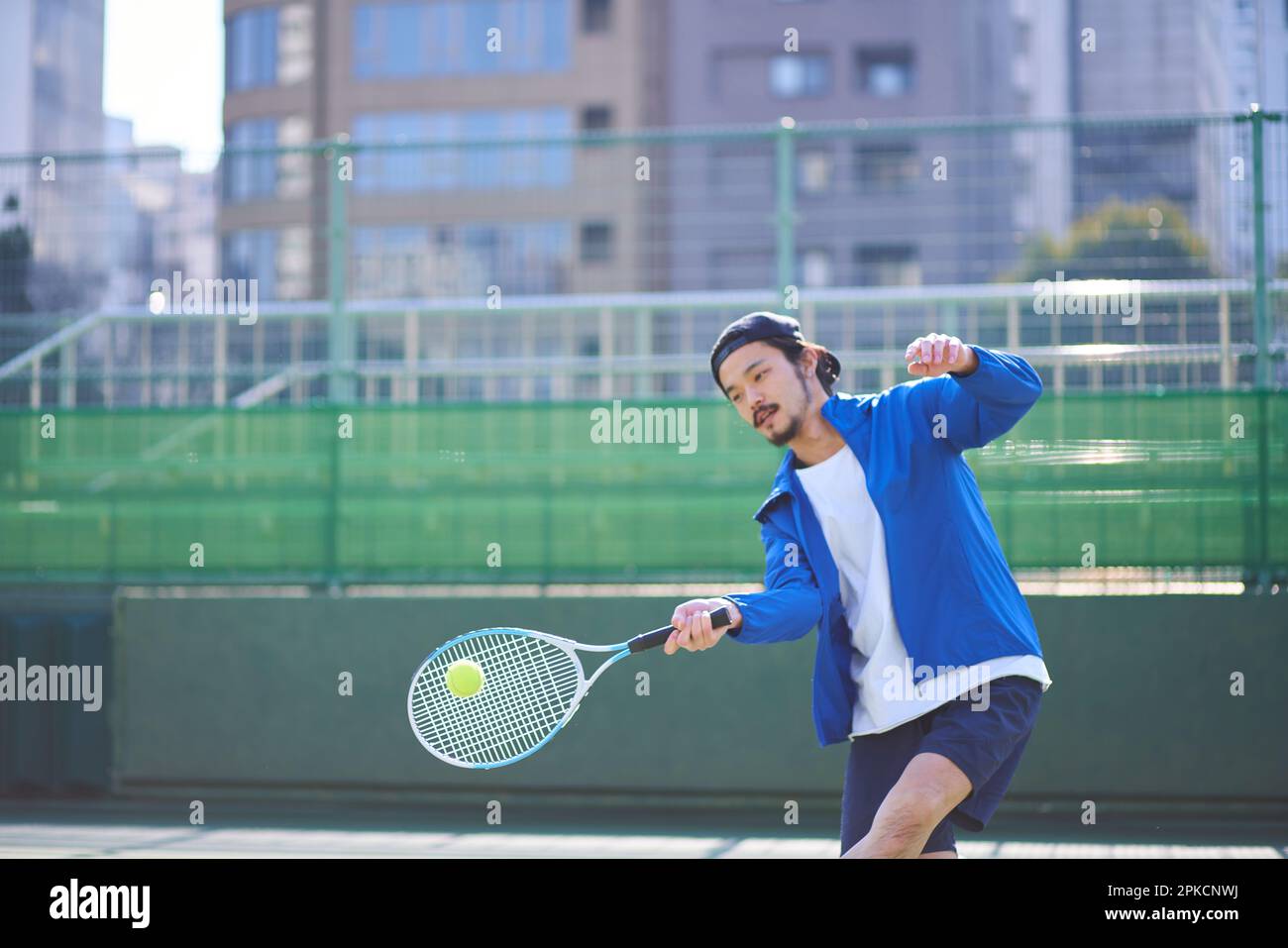 Man hitting a tennis ball back Stock Photo - Alamy