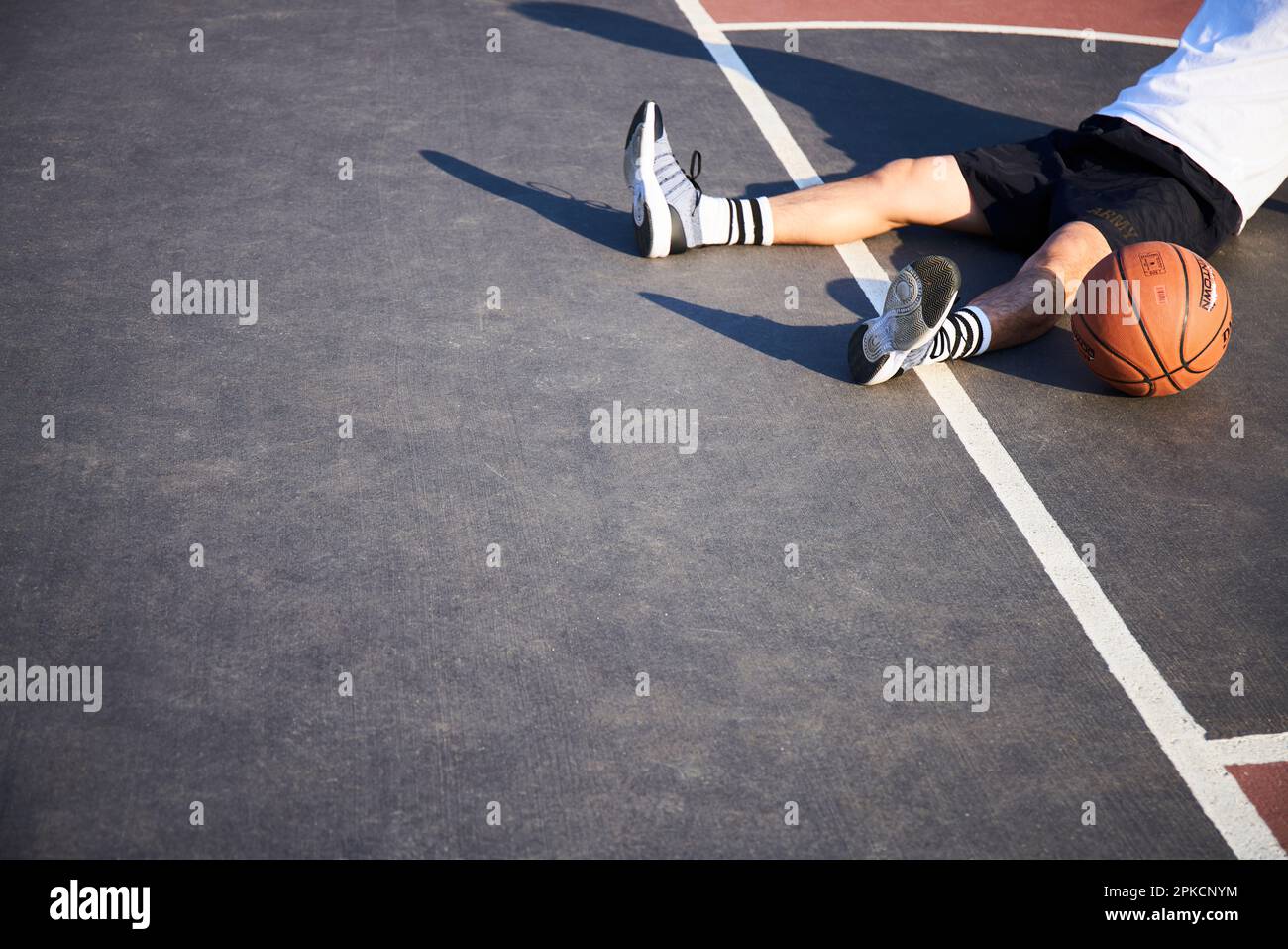 Man resting on basketball court Stock Photo - Alamy