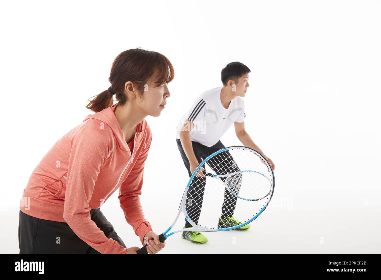 Man and woman setting up rackets in tennis doubles Stock Photo - Alamy