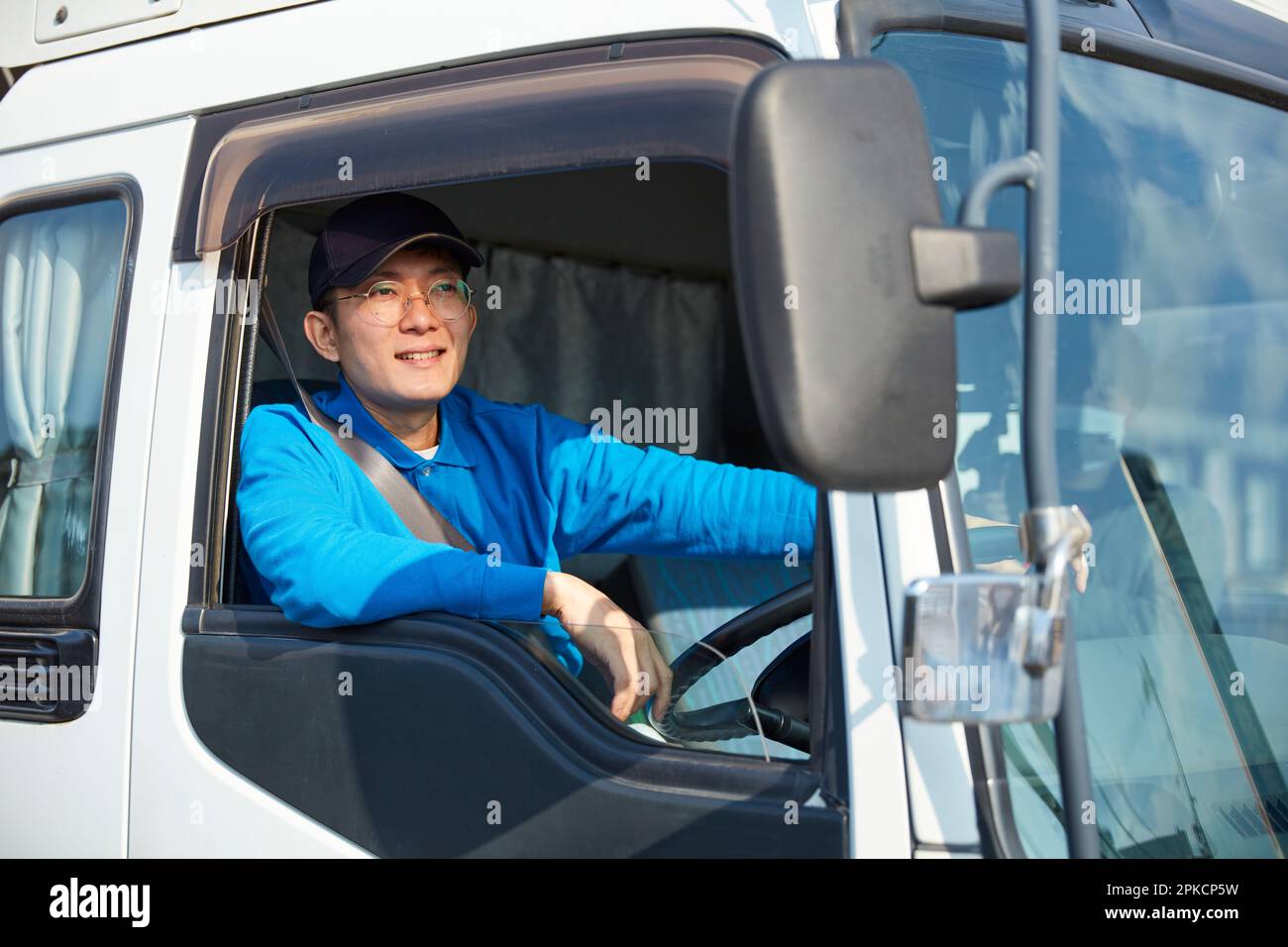 Man in work clothes driving a truck Stock Photo - Alamy