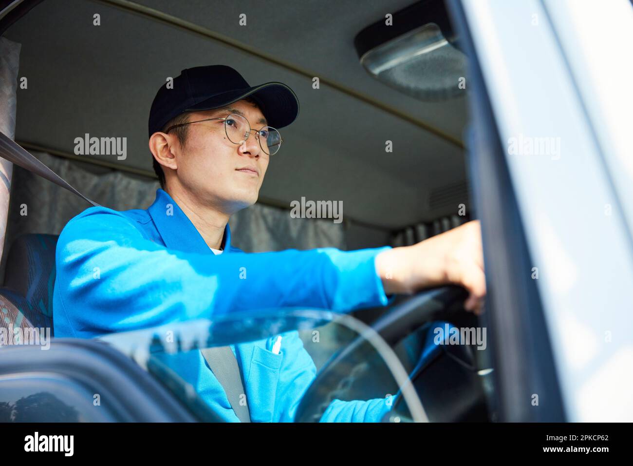 Man in work clothes driving a truck Stock Photo - Alamy
