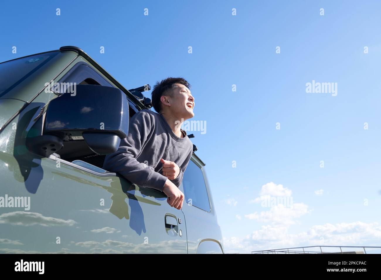 Man leaning out of passenger window of car Stock Photo - Alamy