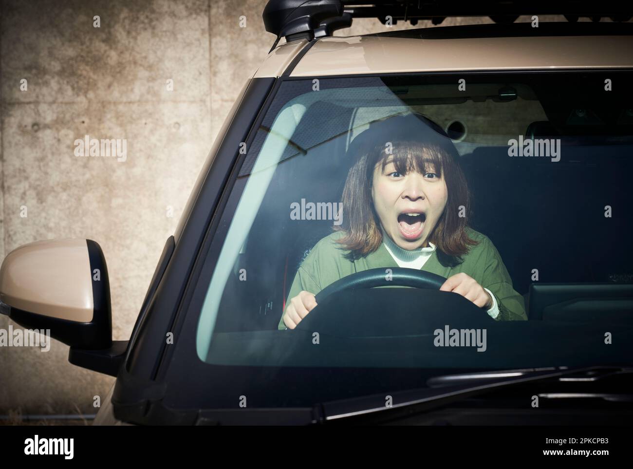 Woman with surprised expression driving a car Stock Photo - Alamy
